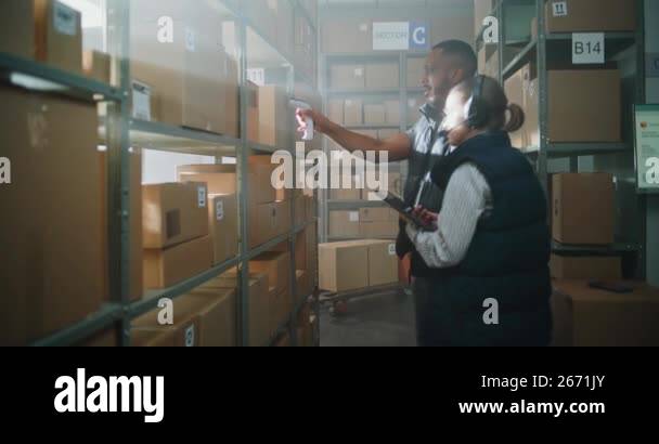 African American Sorting Center Worker Scans Cardboard Boxes with Online Orders with Scanner ...