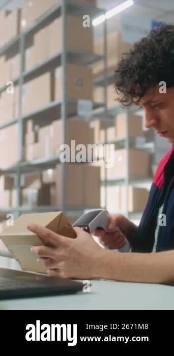 Parcel processing specialist scans package using barcode scanner ...