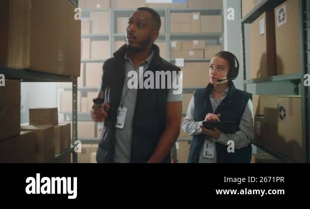 African American Sorting Center Employee Scans Cardboard Boxes with Online Orders with Scanner ...