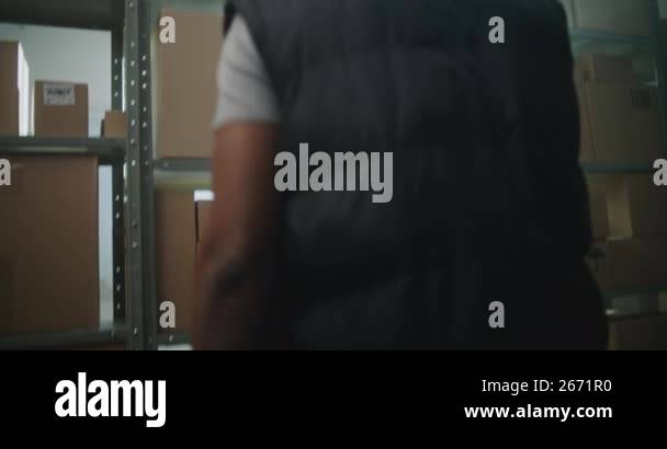Close Up of African American Sorting Center Employee Loading Pallet Truck with Cardboard Boxes ...