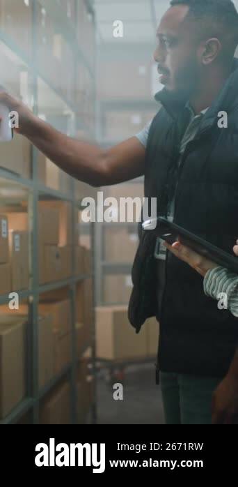 African American Employee Scans Parcels with E-Commerce Goods with Scanner. Female Warehouse ...