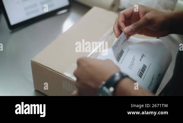 African American Warehouse Clerk Putting Sticker on Package with Online ...