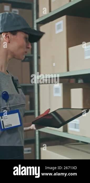 Female Warehouse Worker Scans Cardboard Box with E-Commerce Online Goods on Shelf with Scanner ...