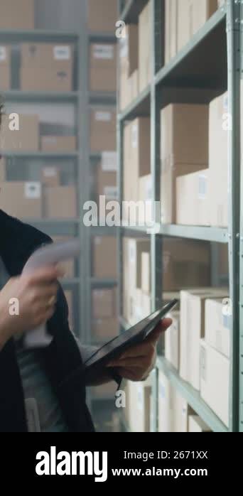 Female Warehouse Associate Scans Cardboard Box with E-Commerce Online Goods on Shelves with ...
