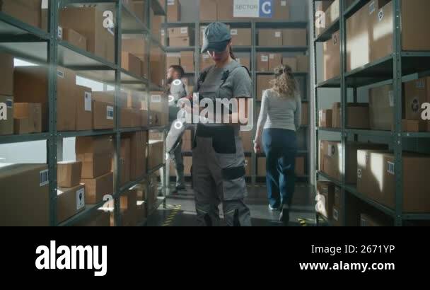 High-Tech Advanced Warehouse: Female Manager Scans Parcels, Checks Inventory on Tablet Computer ...