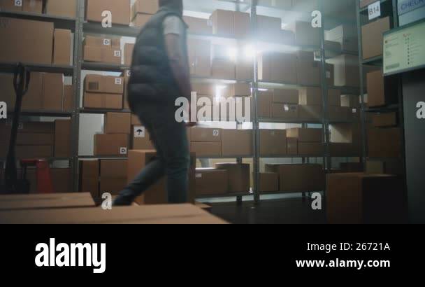 Male African American Warehouse Associate Loads Pallet Truck with Cardboard Boxes in Sorting ...