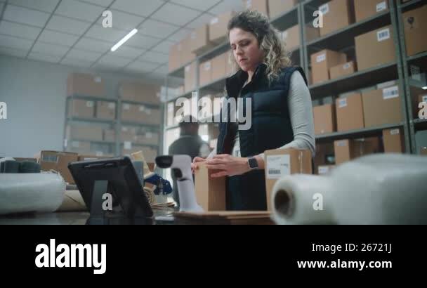 Female Warehouse Clerk Packs Cardboard Box with Online Order, Scans ...