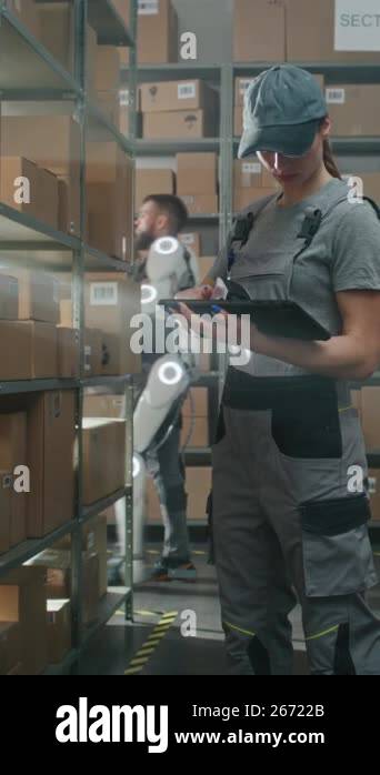 High-Tech Advanced Warehouse: Female Manager Scans Parcels, Checks Inventory on Tablet Computer ...