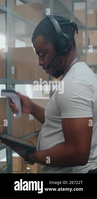 High-Tech Advanced Warehouse: African American Manager in Headset Scans ...