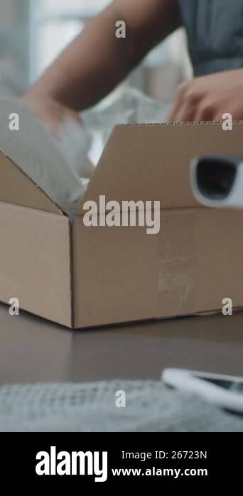 African American Warehouse Clerk Packs Cardboard Box with Order, Scans ...