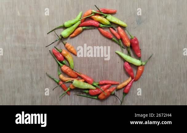 a bunch of cayenne pepper (cabe rawit) with a wooden texture background ...