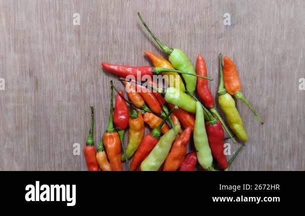 a bunch of cayenne pepper (cabe rawit) with a wooden texture background ...