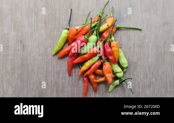 a bunch of cayenne pepper (cabe rawit) with a wooden texture background ...
