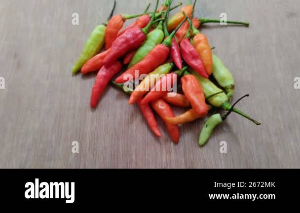 a bunch of cayenne pepper (cabe rawit) with a wooden texture background ...