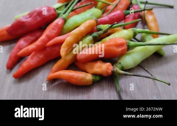 a bunch of cayenne pepper (cabe rawit) with a wooden texture background ...