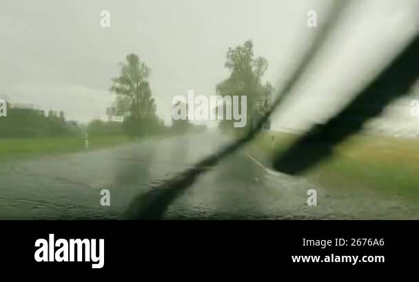 POV view from car driving on road E77 on a asphalt road in rainy summer ...