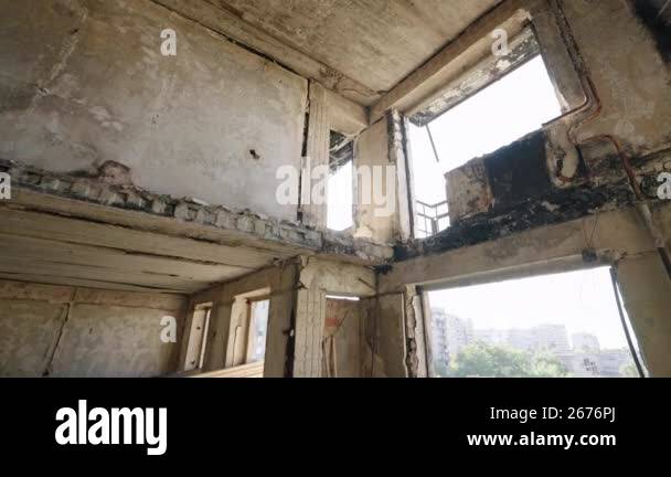 Collapsed ceilings, exposed beams form gloomy backdrop. War-torn ...
