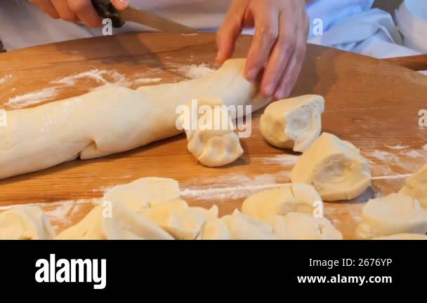 A talented baker expertly cuts fresh dough into perfectly sized pieces ...