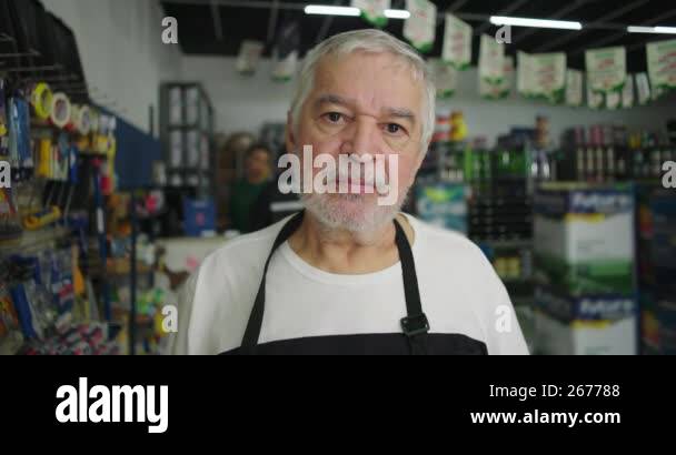 Close-up of older male store owner with thoughtful expression in ...