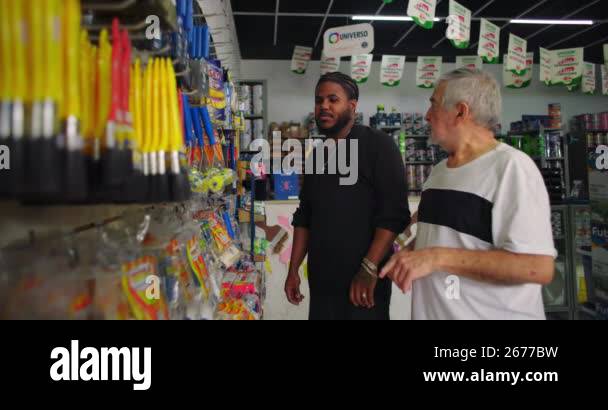 Store clerk assisting a customer in a hardware store aisle, pointing at ...
