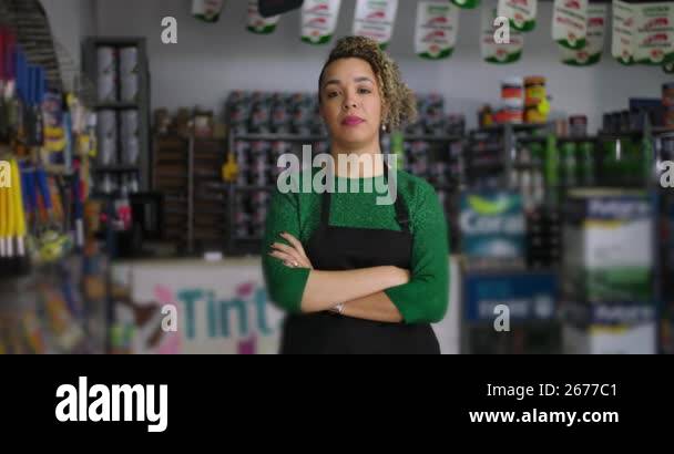Determined hardware store manager with arms crossed, surrounded by ...