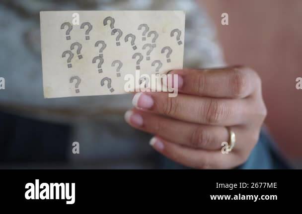 A person holds a card covered in question marks, representing endless ...