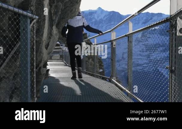 Winter Alpine Trek - Back View of Person Walking on Elevated Metal Path ...