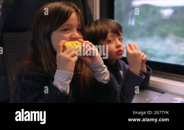 Children eating food while traveling by train, kid passengers snacking ...