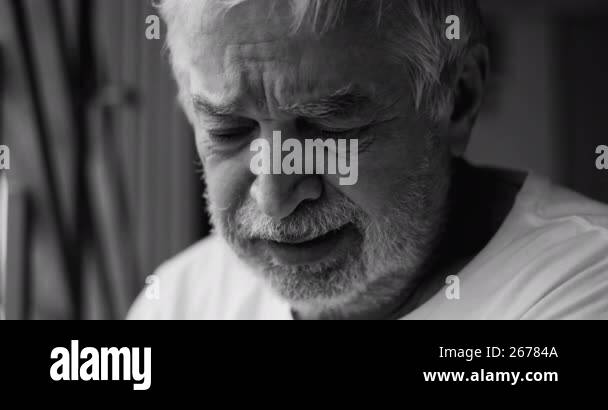 Elderly man close-up with tearful expression of deep sorrow, despair ...