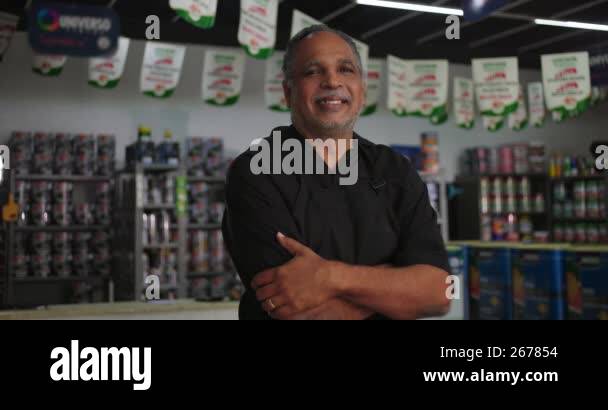 Confident small business owner smiling with arms crossed in his ...