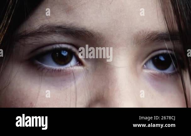 Tight macro close-up of child's eye with contemplative gaze staring at ...