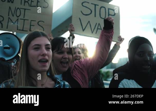 Young blonde woman with group diverse people protesting angry shouting ...