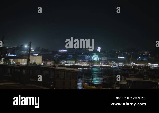 Colorful ferris wheel lights reflecting on dark waters of Douro river ...