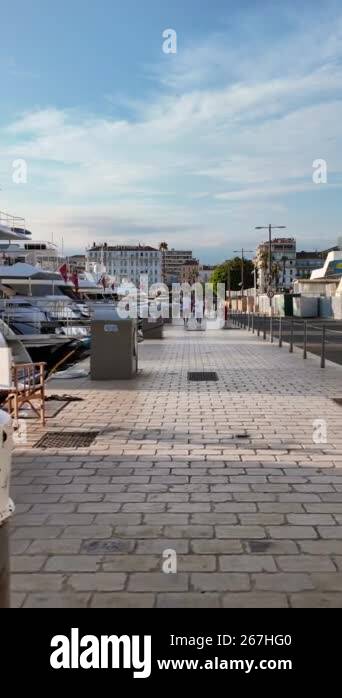 Cannes, France - October 15, 2024: People walking near boats docked in ...