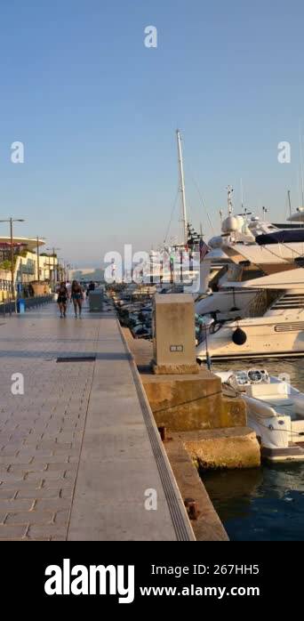 Cannes, France - October 15, 2024: People walking near boats docked in ...