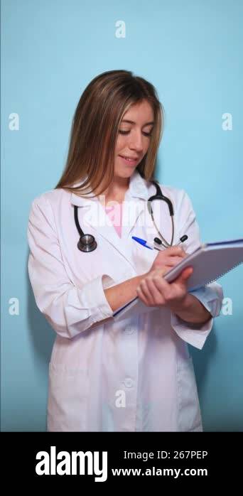 vertical Medical professional in white lab coat documenting patient ...