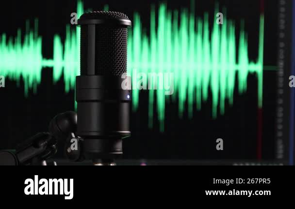 microphone in focus with audio waveform recording in the background ...