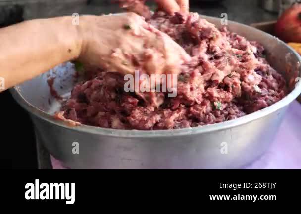 Person is making meatballs in a bowl. The meatballs are being mixed and ...