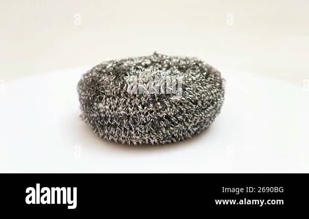 Stainless steel scrubber, metal pot sponge isolated rotating on white ...