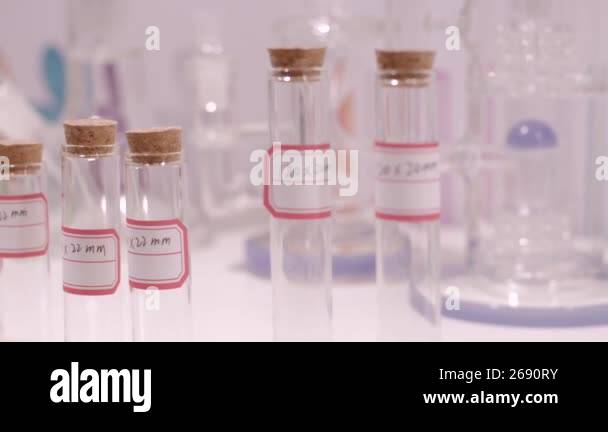 Collection of labeled test tubes and laboratory glassware, scientific ...