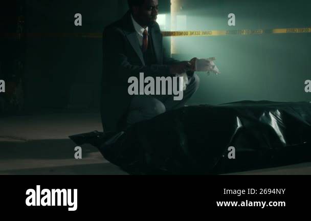 Tilt up shot of young Black male forensic expert putting on gloves ...