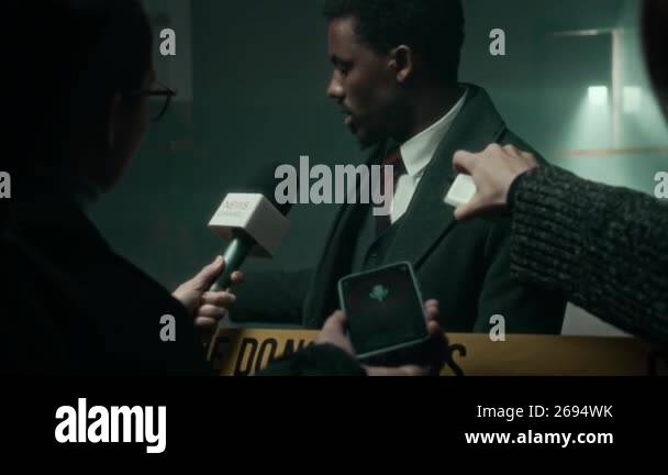 Over-the-shoulder lowkey shot of young Black male police officer ...