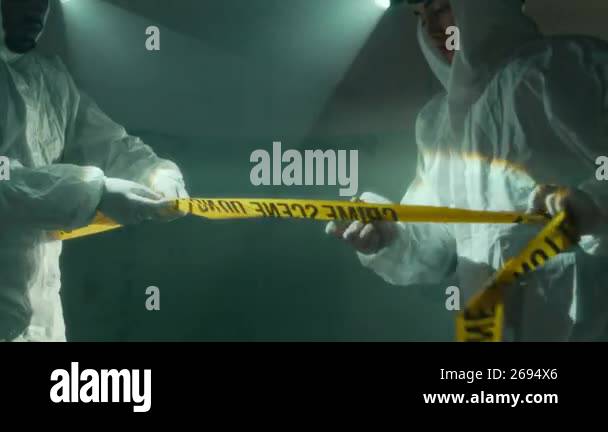 Tracking lowkey shot of multiethnic forensic colleagues in protective ...