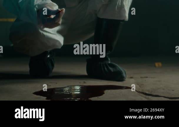 Tilt up lowkey shot of young Caucasian female forensic expert in ...