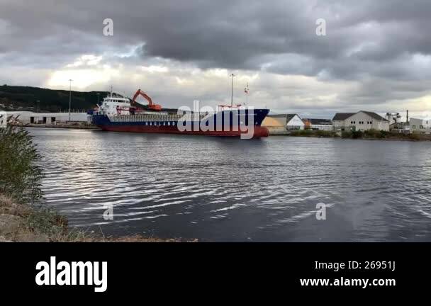 Cargo freight ship being loaded with goods at the docks in Inverness ...