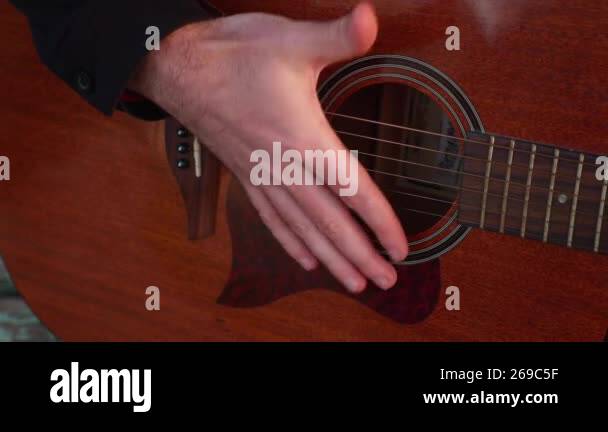 Close up of man's hand beats the rhythm on a guitar deck. Learning to ...