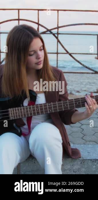 Girl playing bass guitar in the nature near the beach Stock Video ...