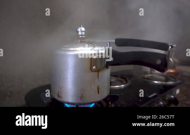 A pressure cooker whistles as it releases hot, pressurized steam in an ...