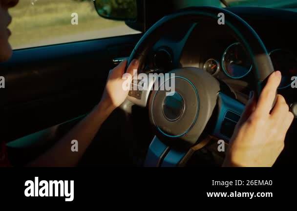 Hands gripping steering wheel driving automobile through sunny ...