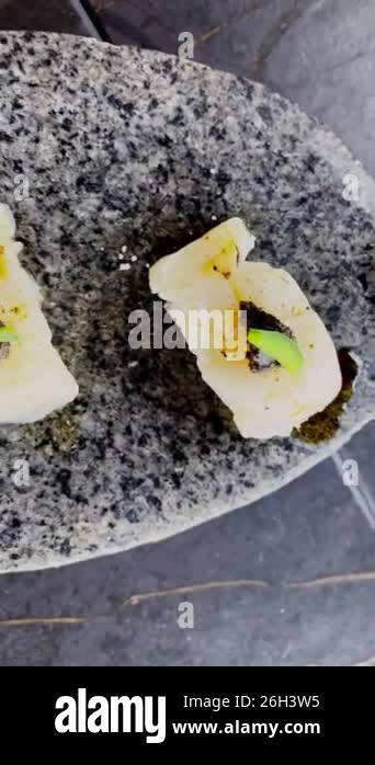 Luxury sushi with white fish, truffle oil, and sauces on a stone plate ...